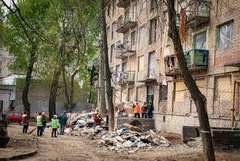 People gather around a damaged building in Kyiv, Ukraine.